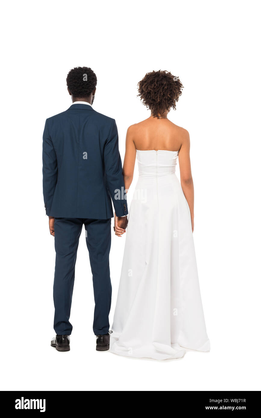back view of african american bridegroom and bride standing and holding ...