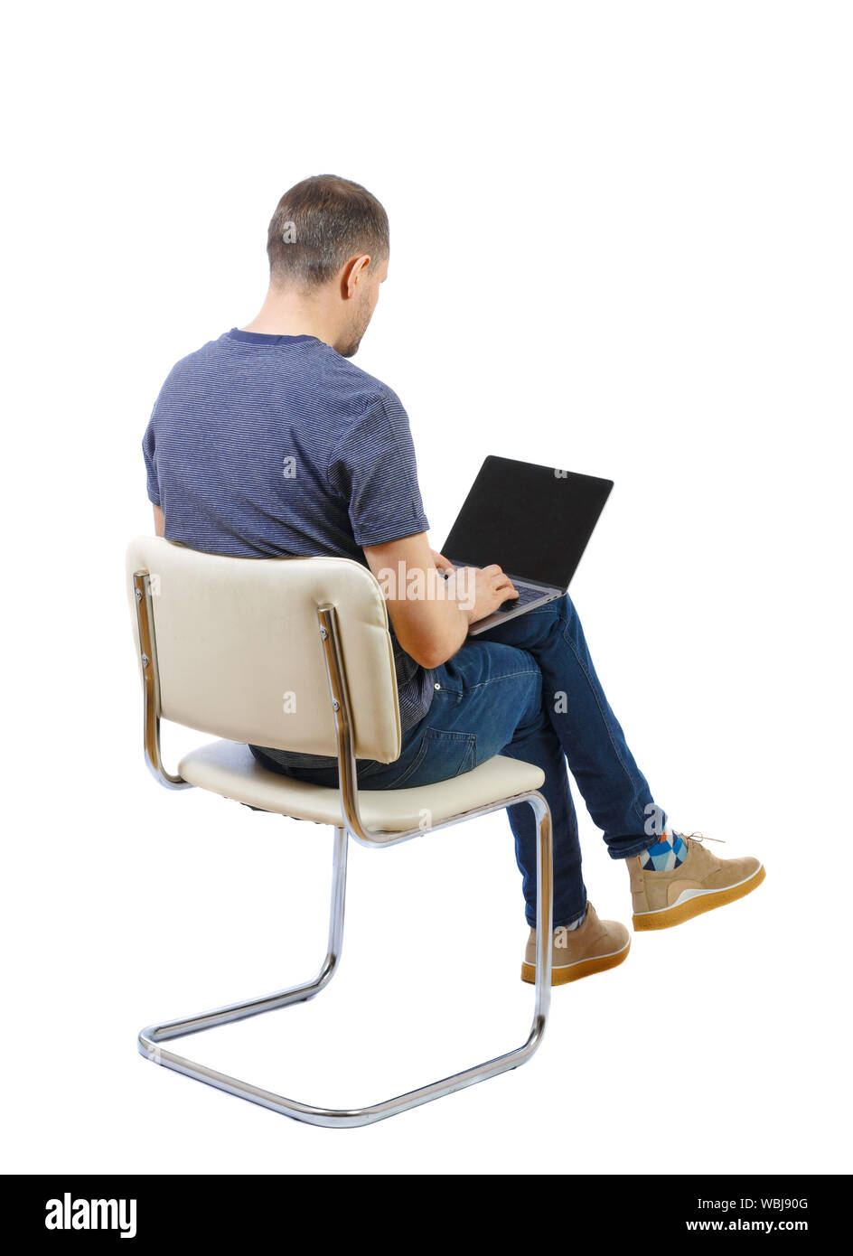 Rear view of a man who sits on a chair with a laptop. Rear view people ...