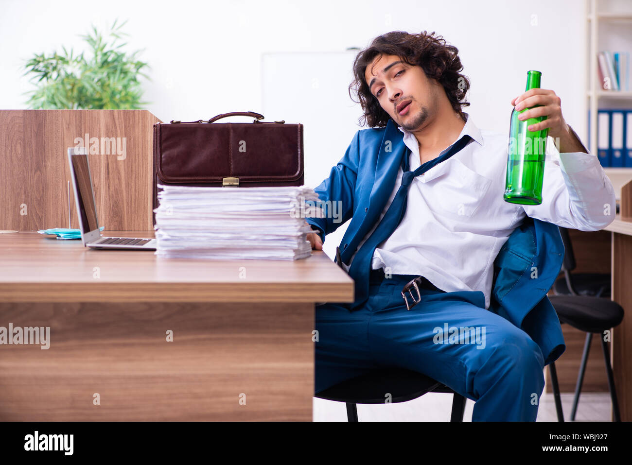 The young drunk employee in the office Stock Photo - Alamy