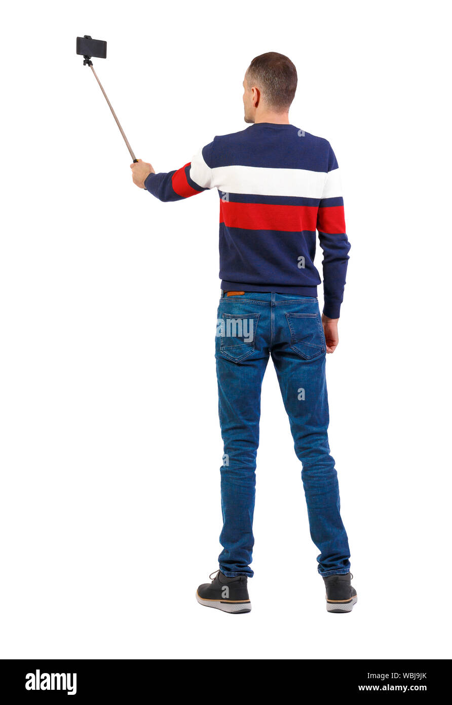 back view of standing young guy with smartphone in the hands of. Rear ...