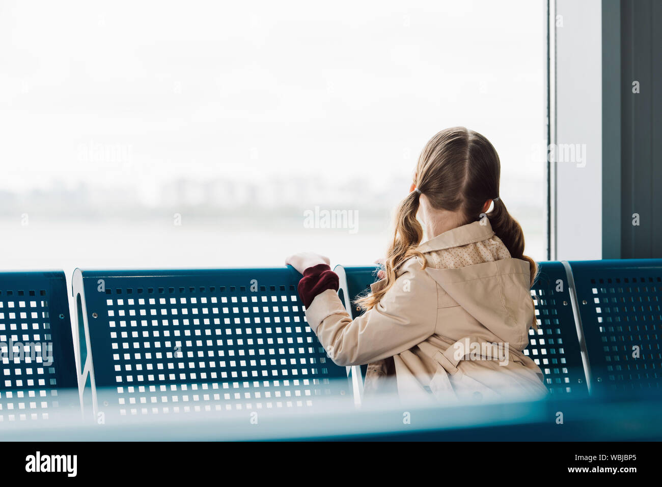 back view of preteen kid looking at window in departure lounge Stock ...