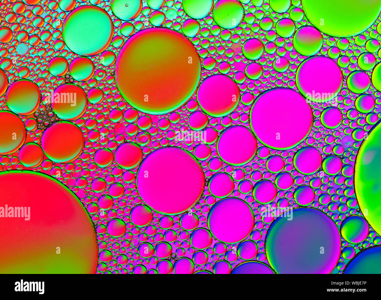Multi-coloured bubble patterns formed by oil floating on water Stock ...