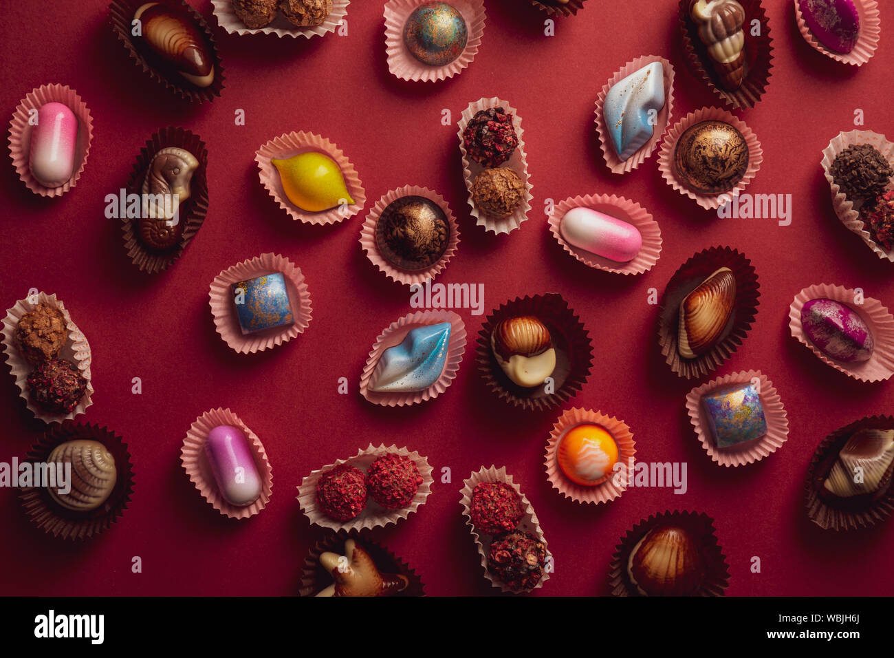 Red background with sweet chocolate candies Stock Photo - Alamy