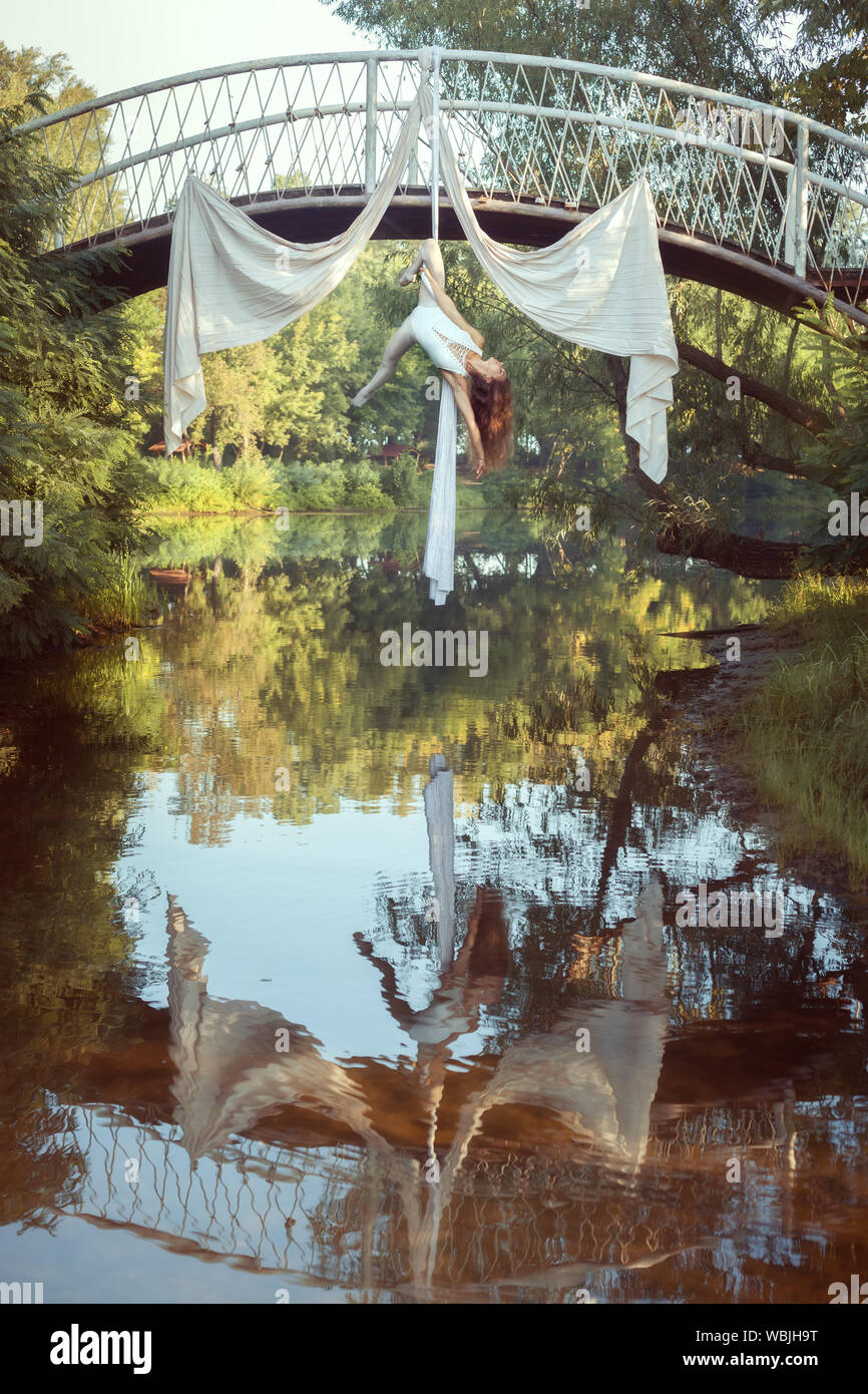 There are white canvases above the river on the bridge, on them an ...