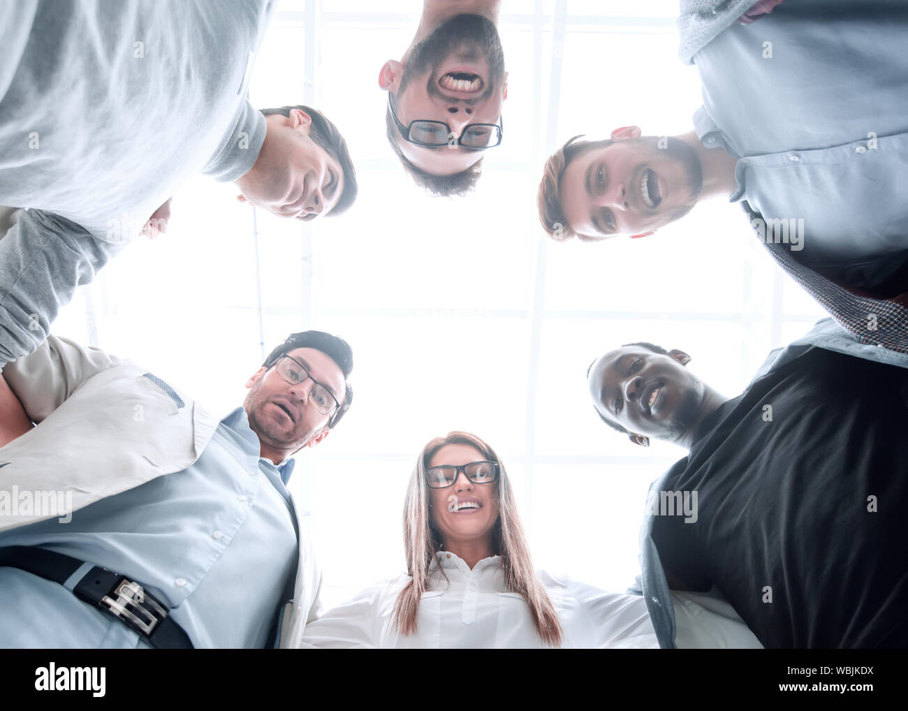bottom view.a group of young people stand together, forming a circle ...