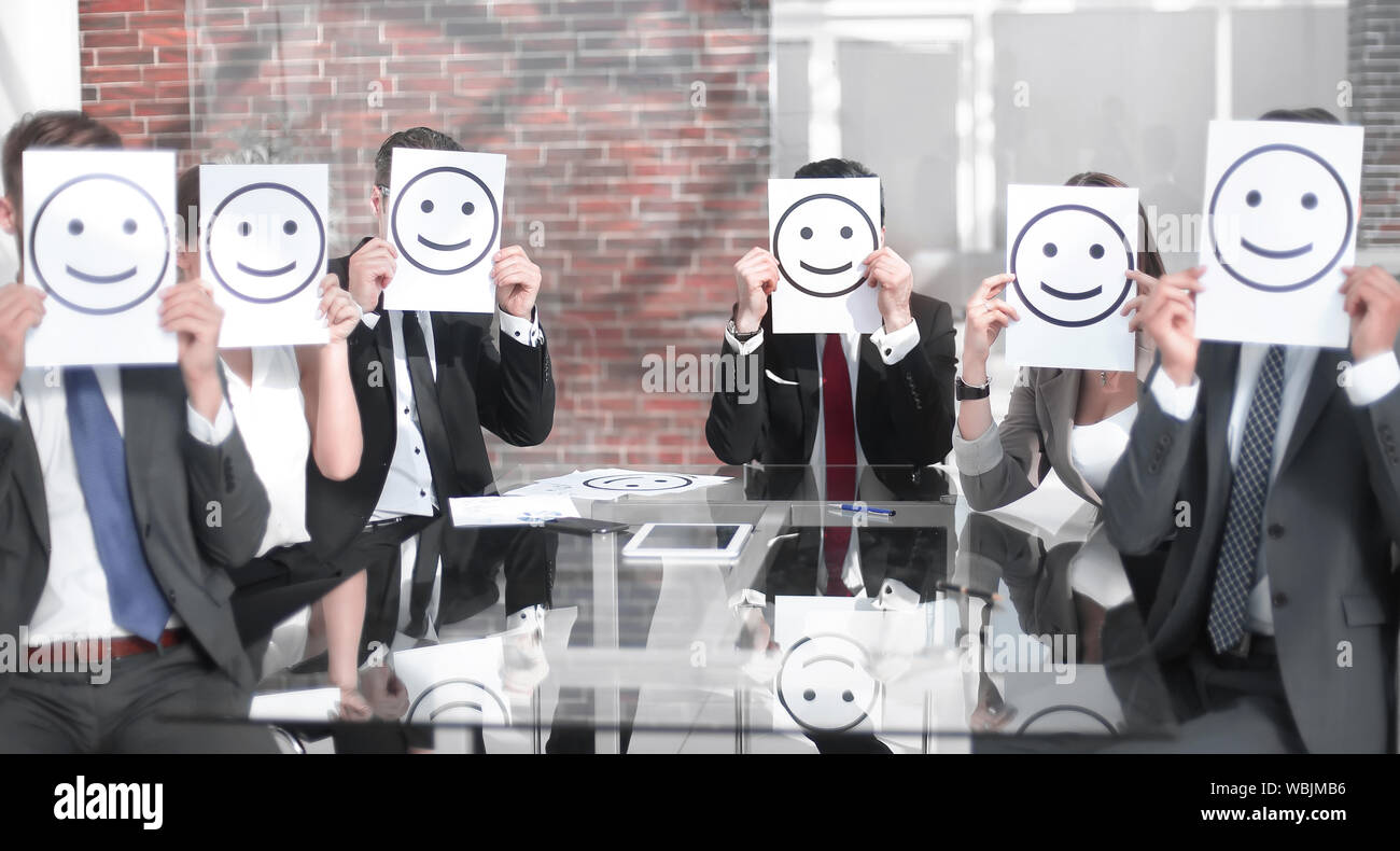 business team keeps smiley icons sitting at the Desk Stock Photo - Alamy