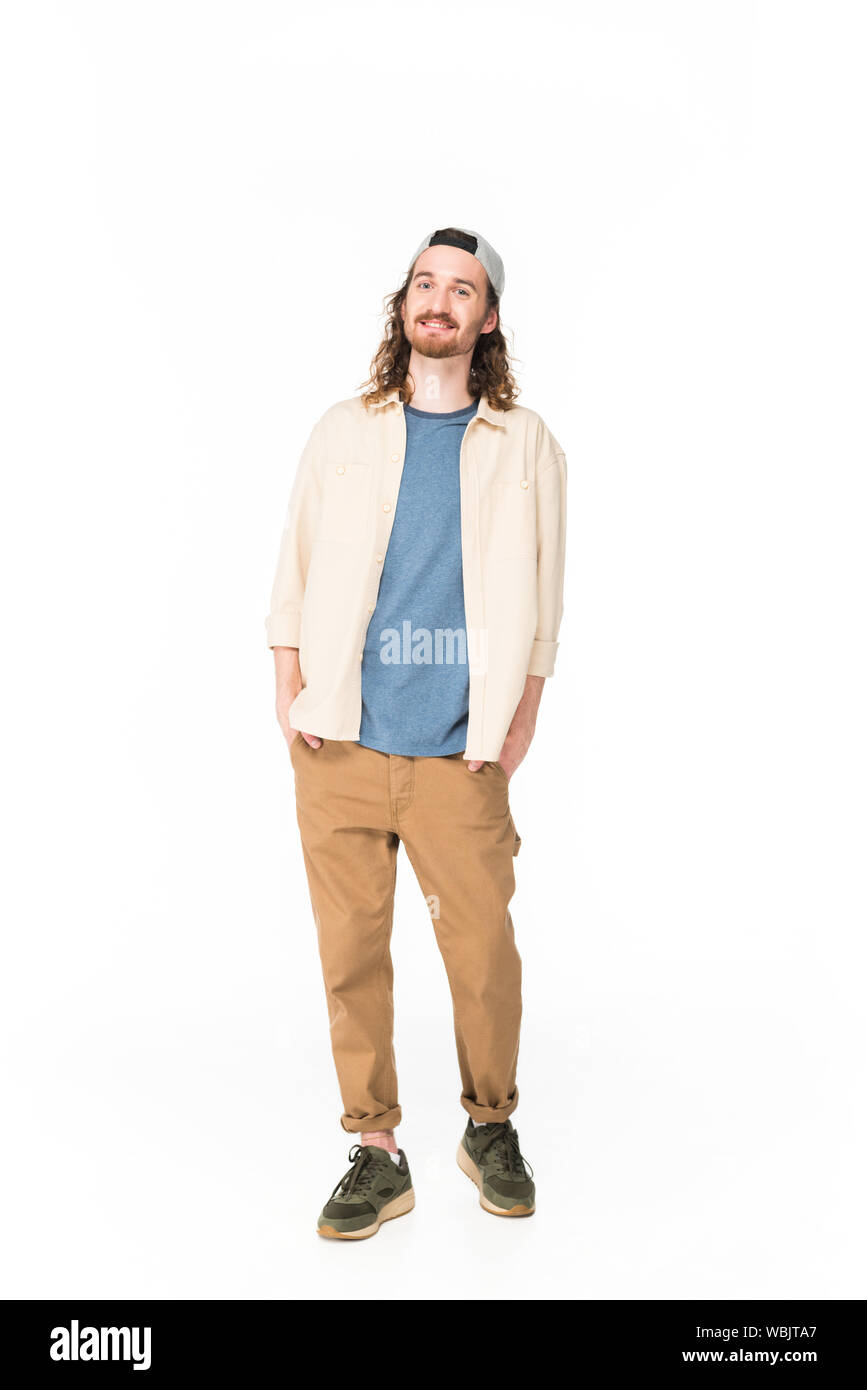 full length view of handsome young man holding hands in pockets and ...