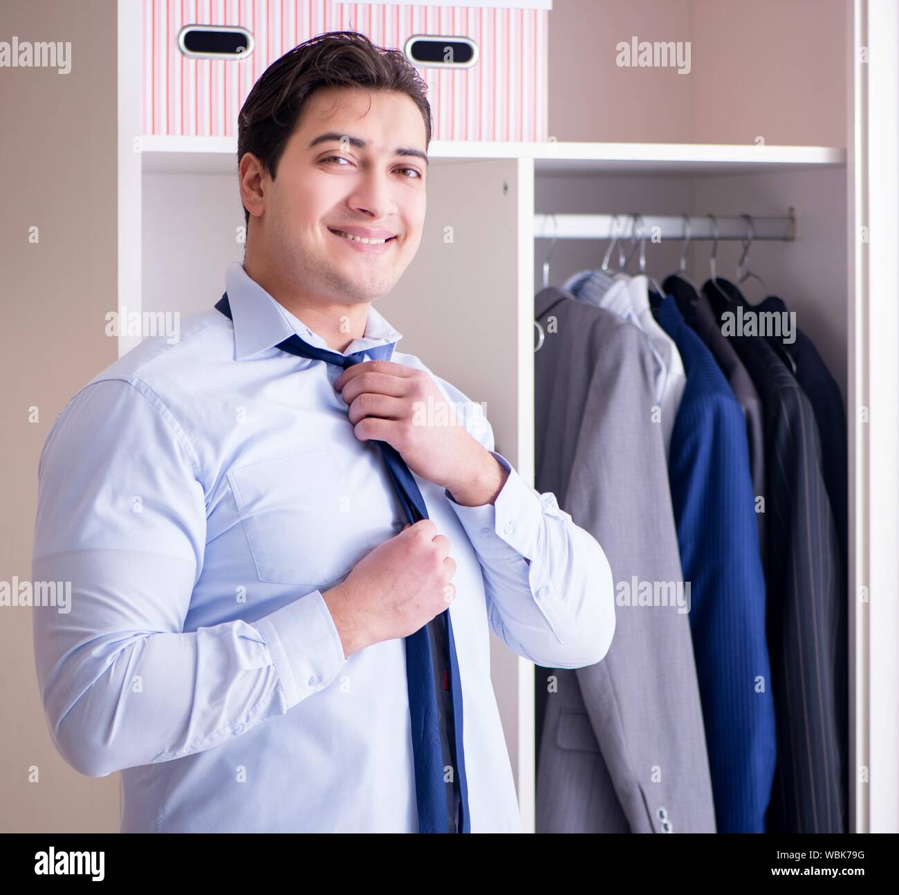 The young man businessman getting dressed for work Stock Photo - Alamy