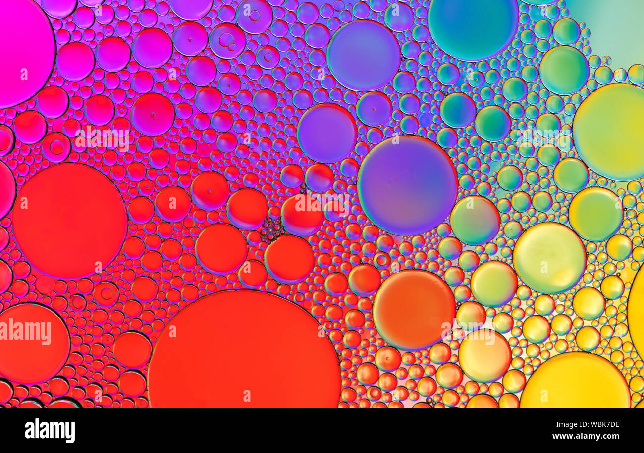 Multi-coloured bubble patterns formed by oil floating on water Stock ...