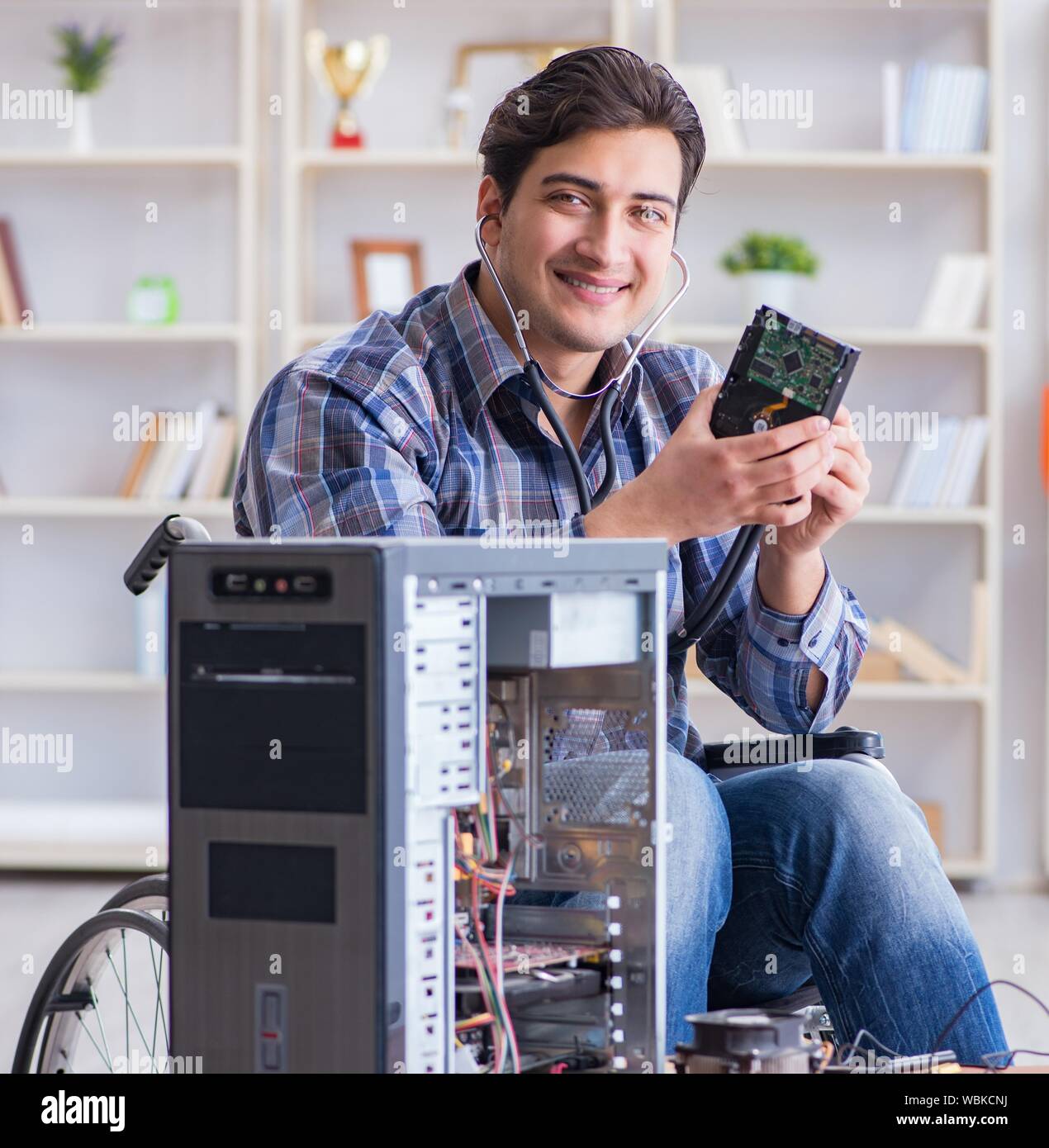 The computer repairman on wheelchair working Stock Photo - Alamy