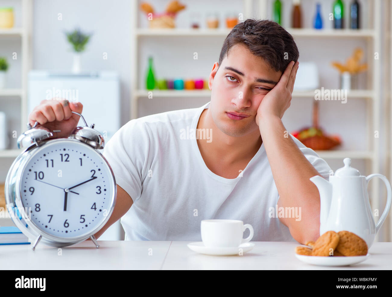 The man with alarm clock falling asleep at breakfast Stock Photo - Alamy