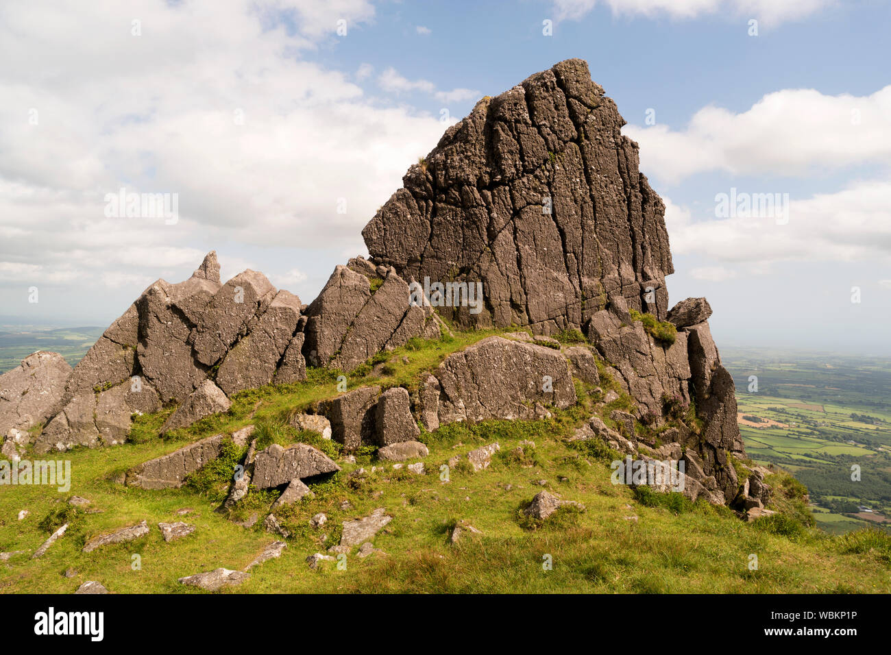 Pinnacle on the top of a mountain peak with a view to the valley below ...