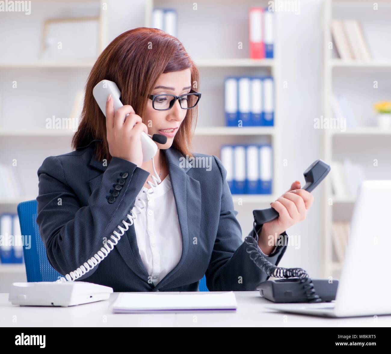 The frustrated call center assistant responding to calls Stock Photo ...