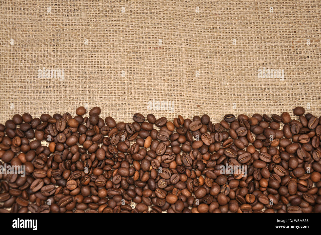 Coffee beans on rag cloth background. Texture design Stock Photo - Alamy