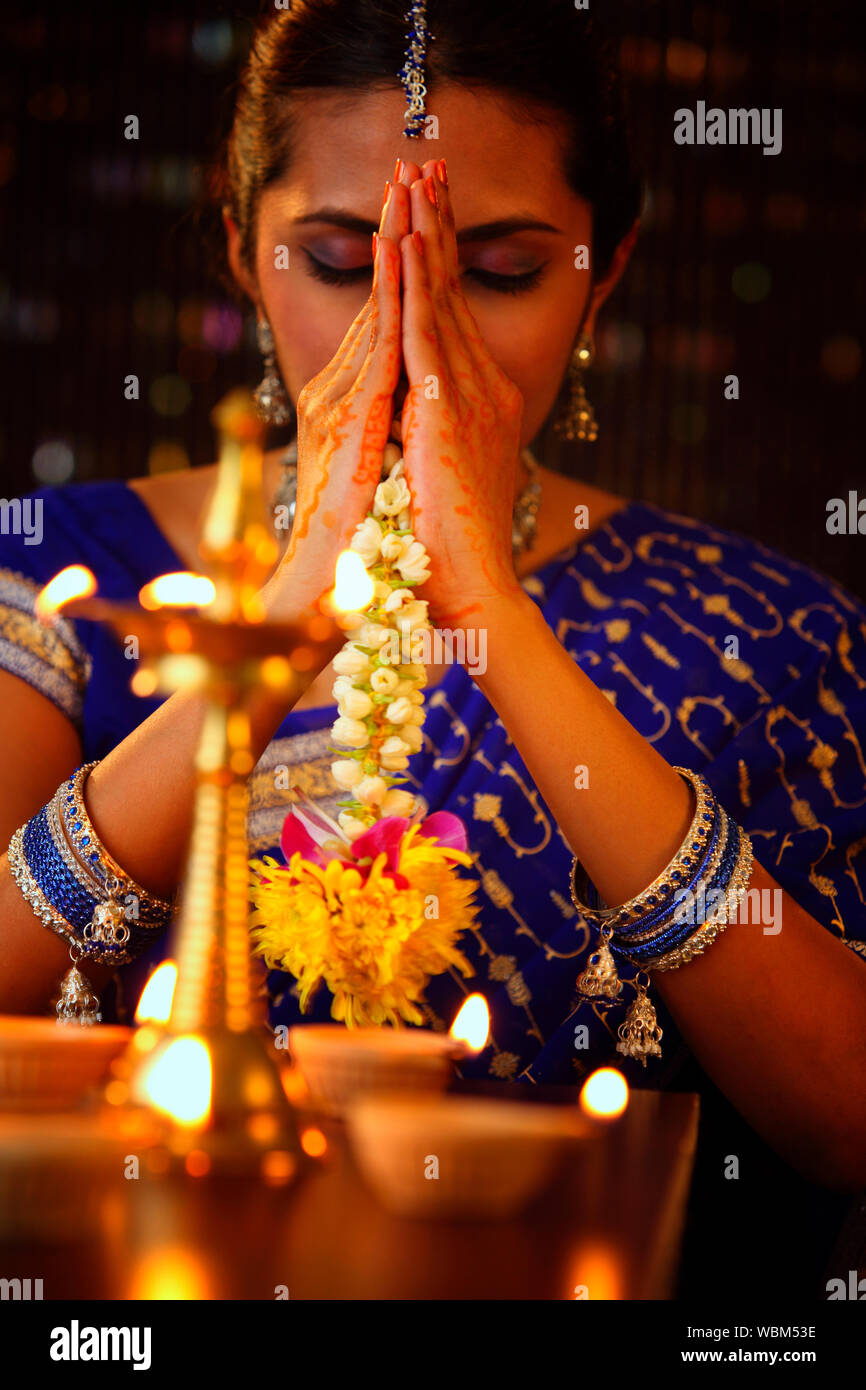 Woman praying oil lamp in hi-res stock photography and images - Alamy