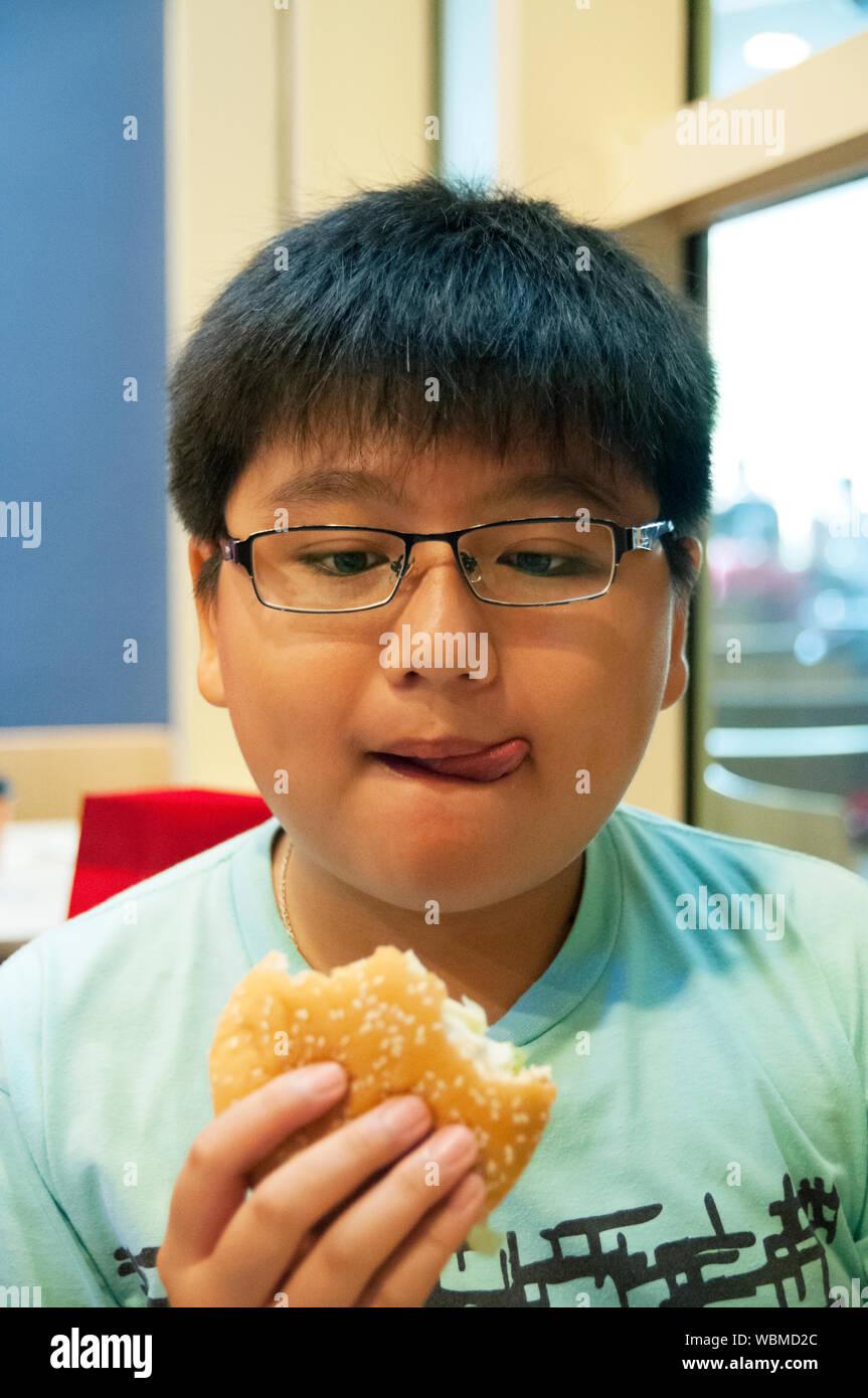 Boy eating burger hi-res stock photography and images - Alamy
