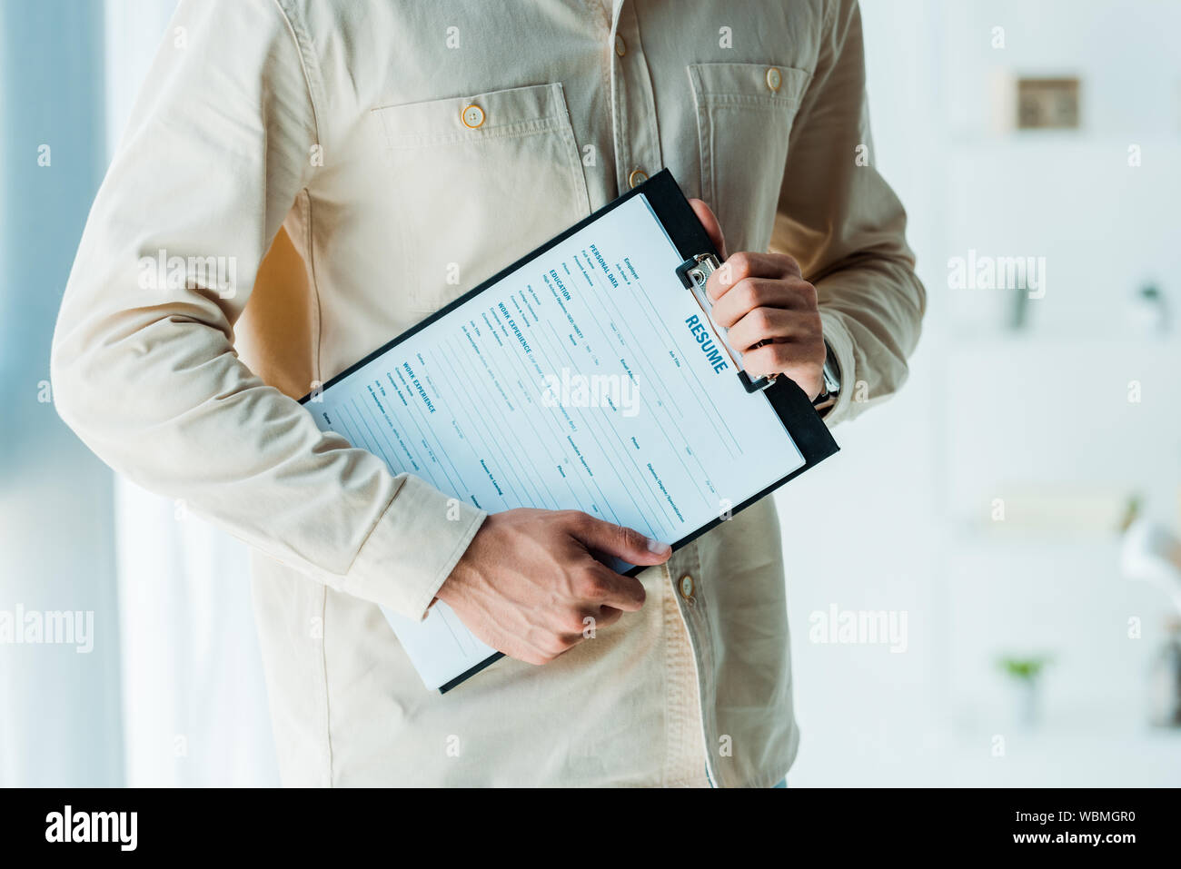 cropped view of man holding clipboard while standing in office Stock ...