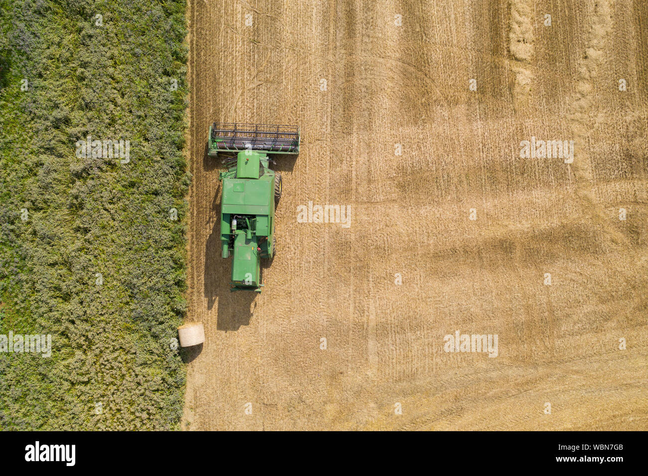Aerial view over a green combine harvester in a farm field Stock Photo ...