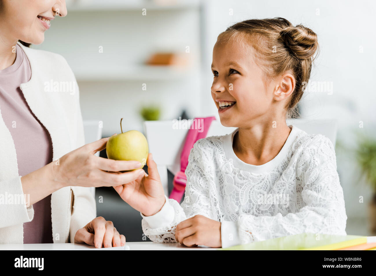 cropped view of happy mother giving apple to daughter Stock Photo - Alamy