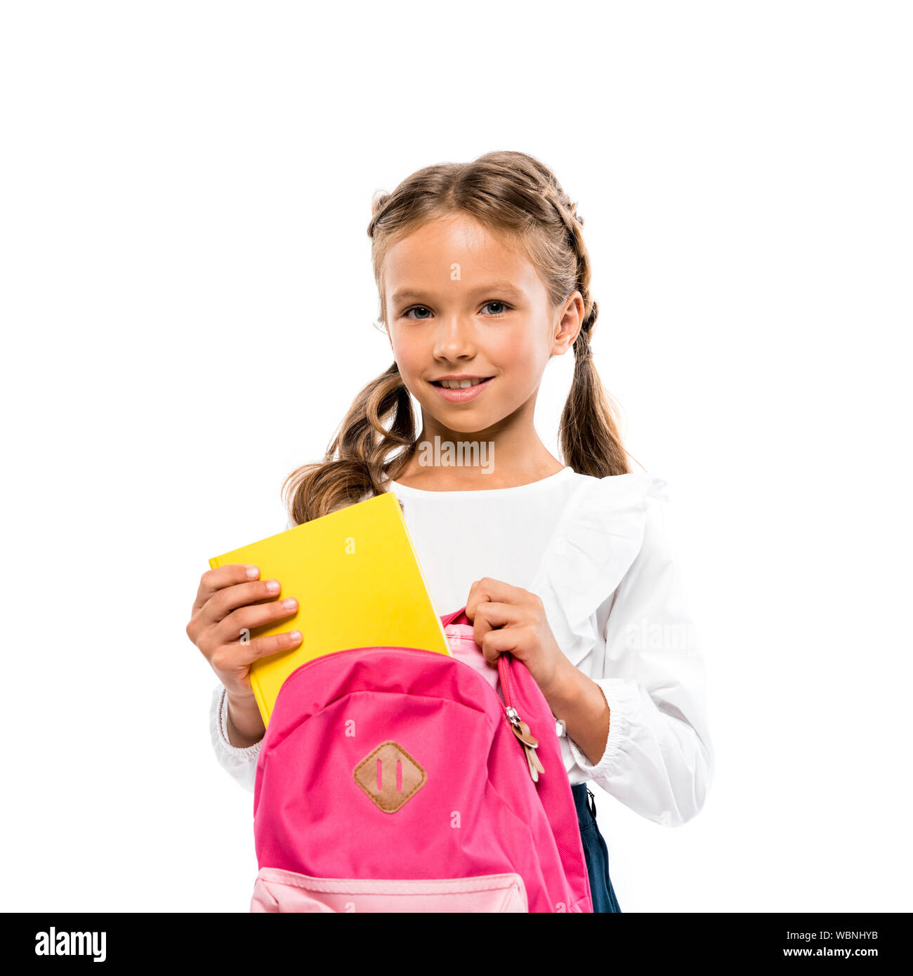 smiling child putting book in pink backpack isolated on white Stock ...