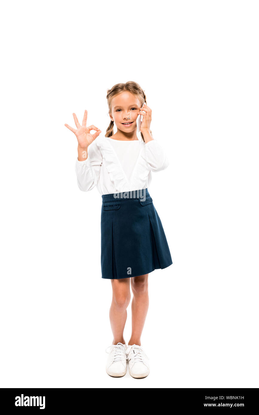 happy kid showing ok sign while talking on smartphone isolated on white ...