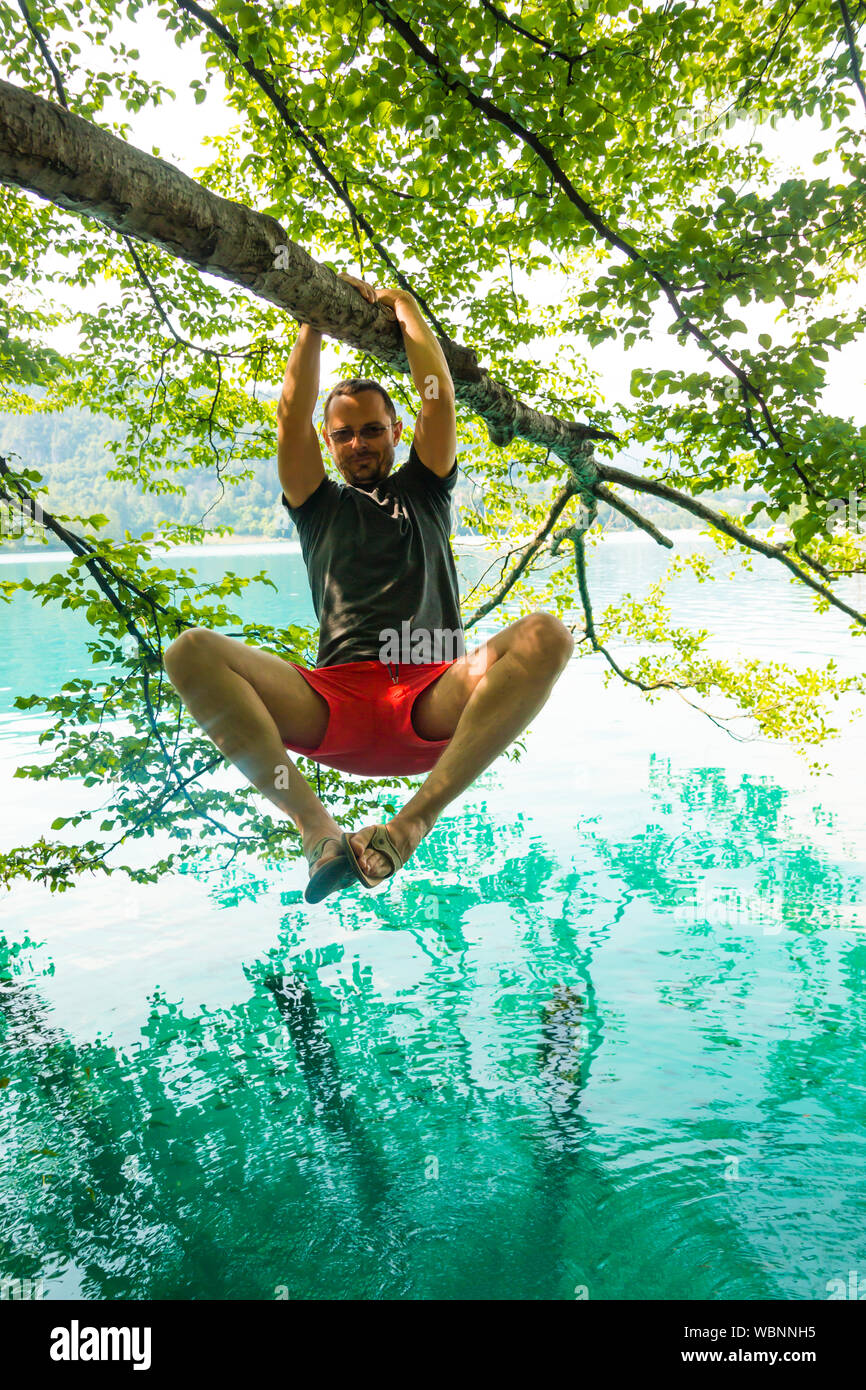 Young man hanging on branch hi-res stock photography and images - Alamy
