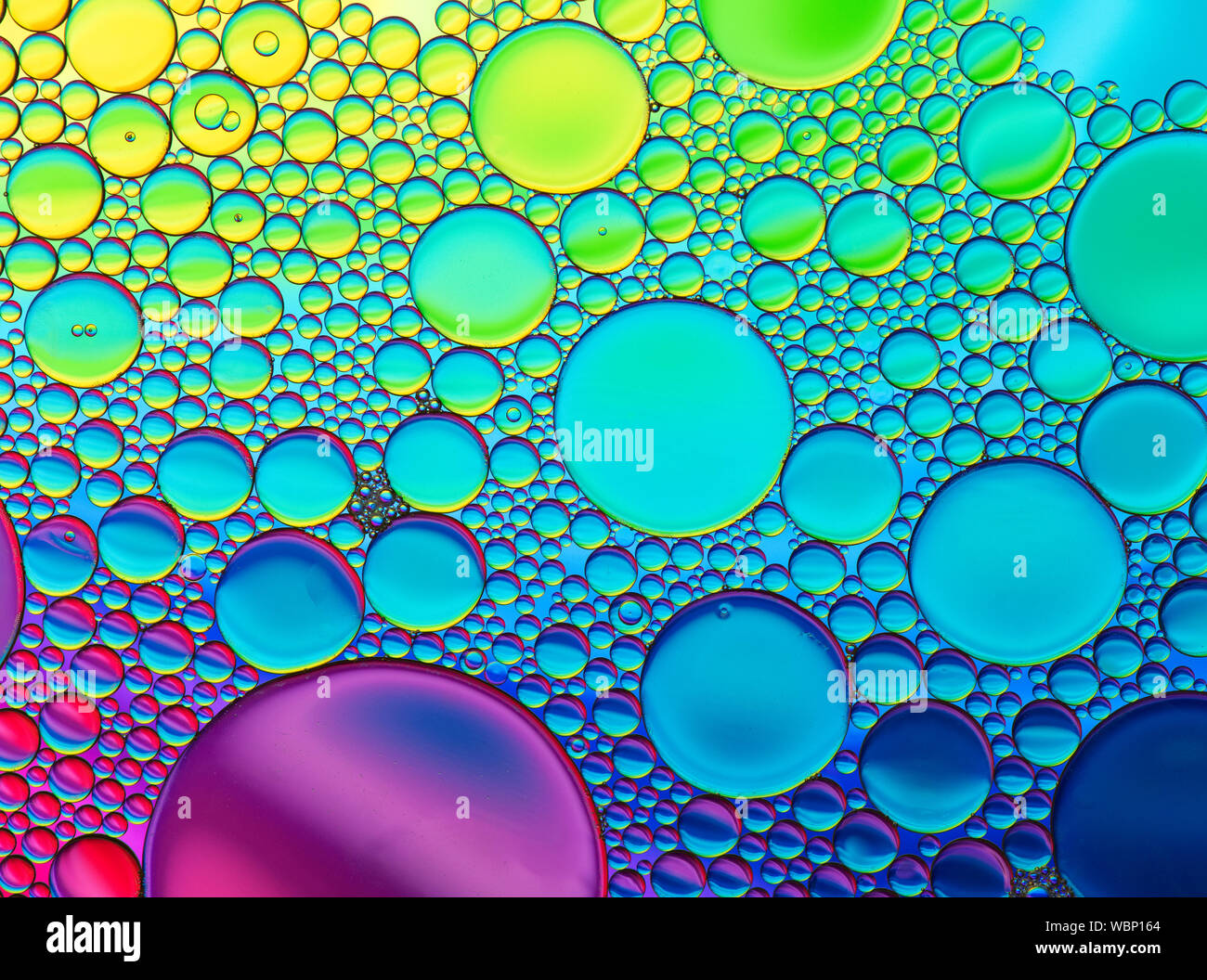 Multi-coloured bubble patterns formed by oil floating on water Stock ...