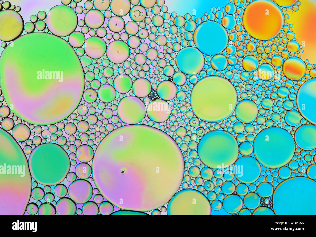 Multi-coloured bubble patterns formed by oil floating on water Stock ...