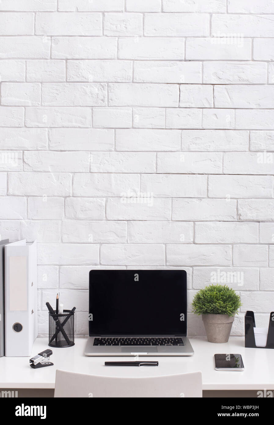 Modern white office desk with blank screen on laptop Stock Photo - Alamy