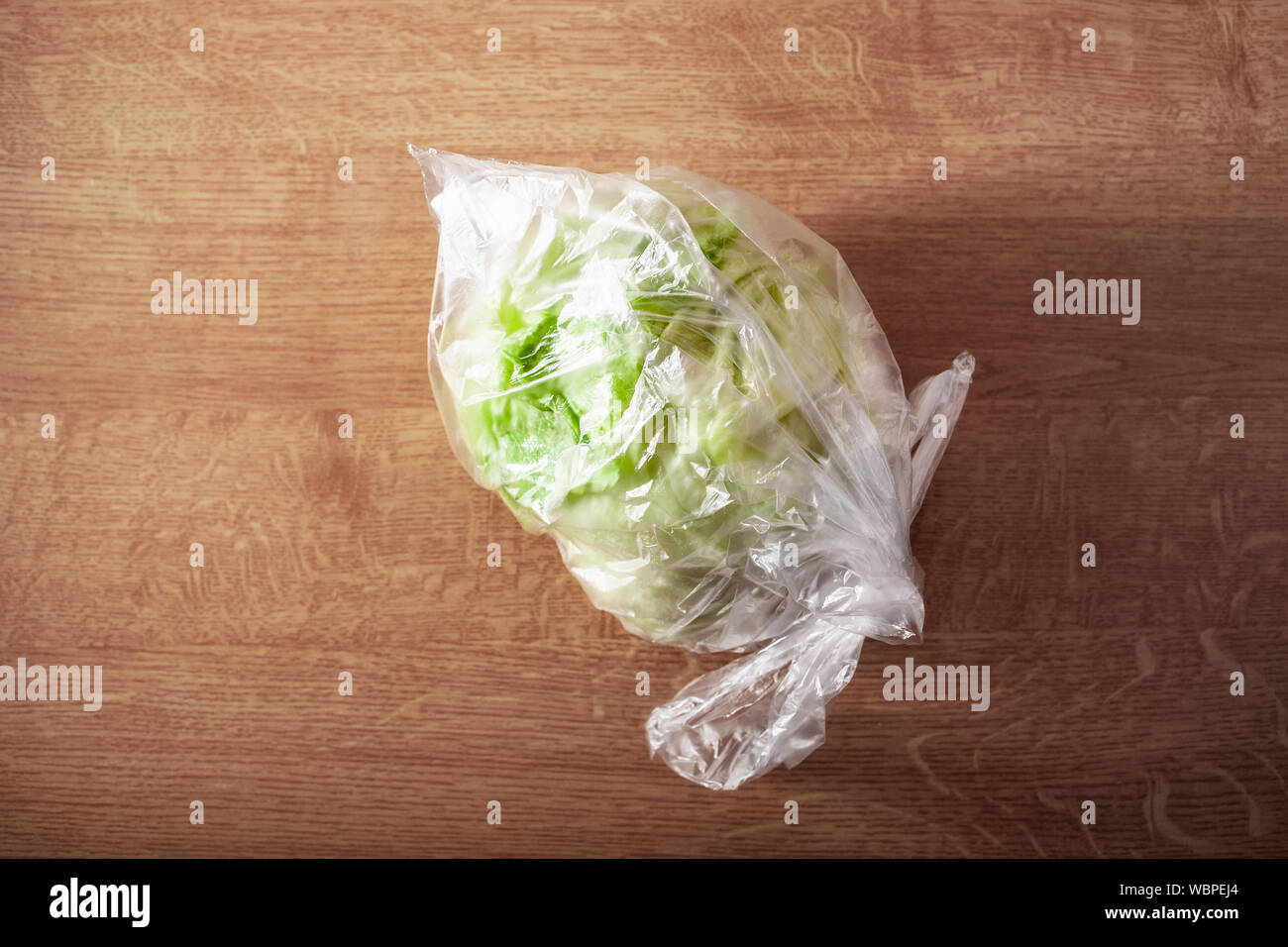 iceberg lettuce vegetable in plastic bag. single use plastic packaging ...
