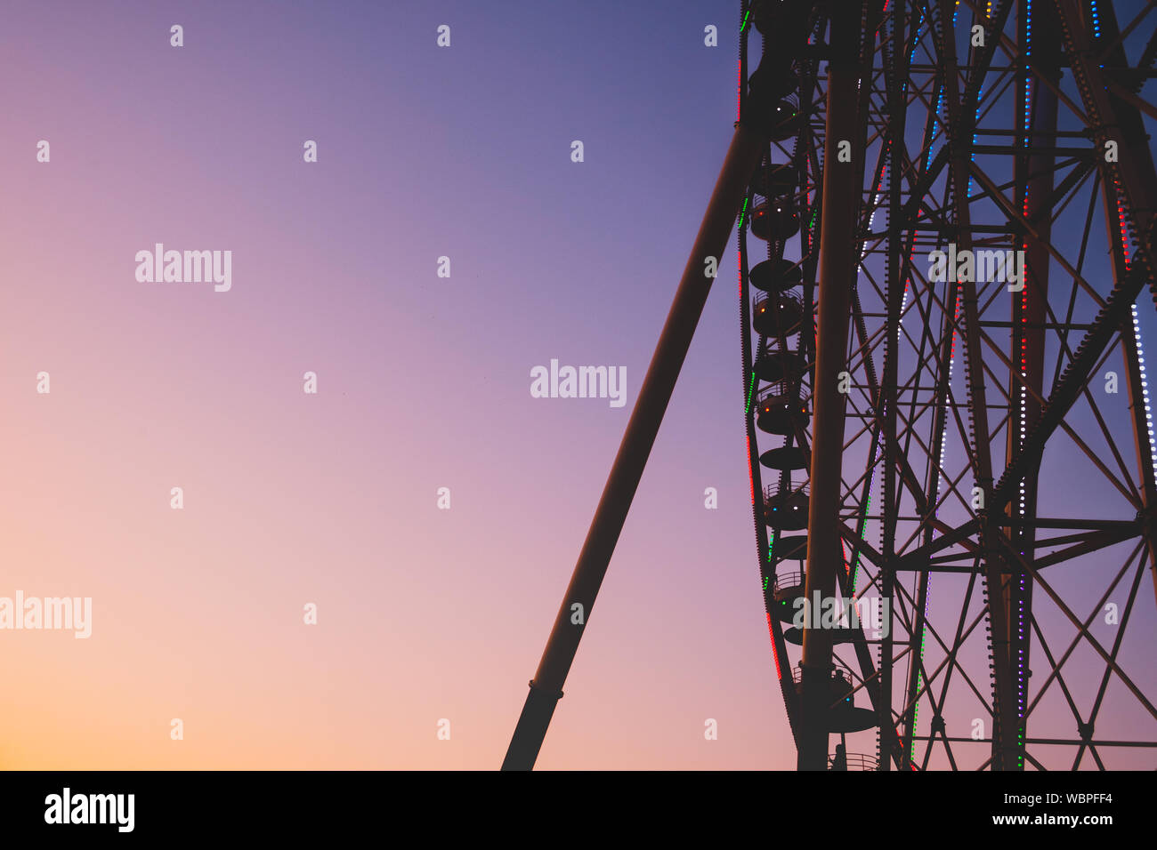 Observation wheel silhouette in bright evening sky. Fairground ride and ...