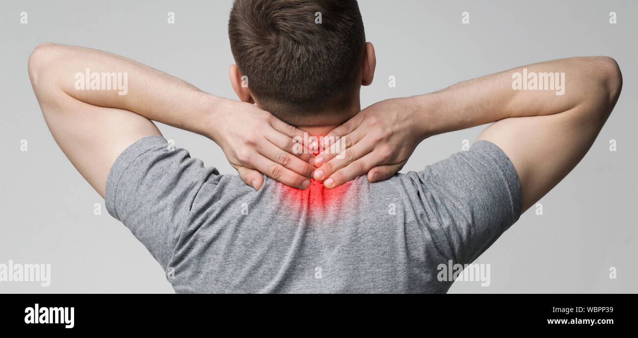 Millennial guy touching his sore neck, back view Stock Photo - Alamy