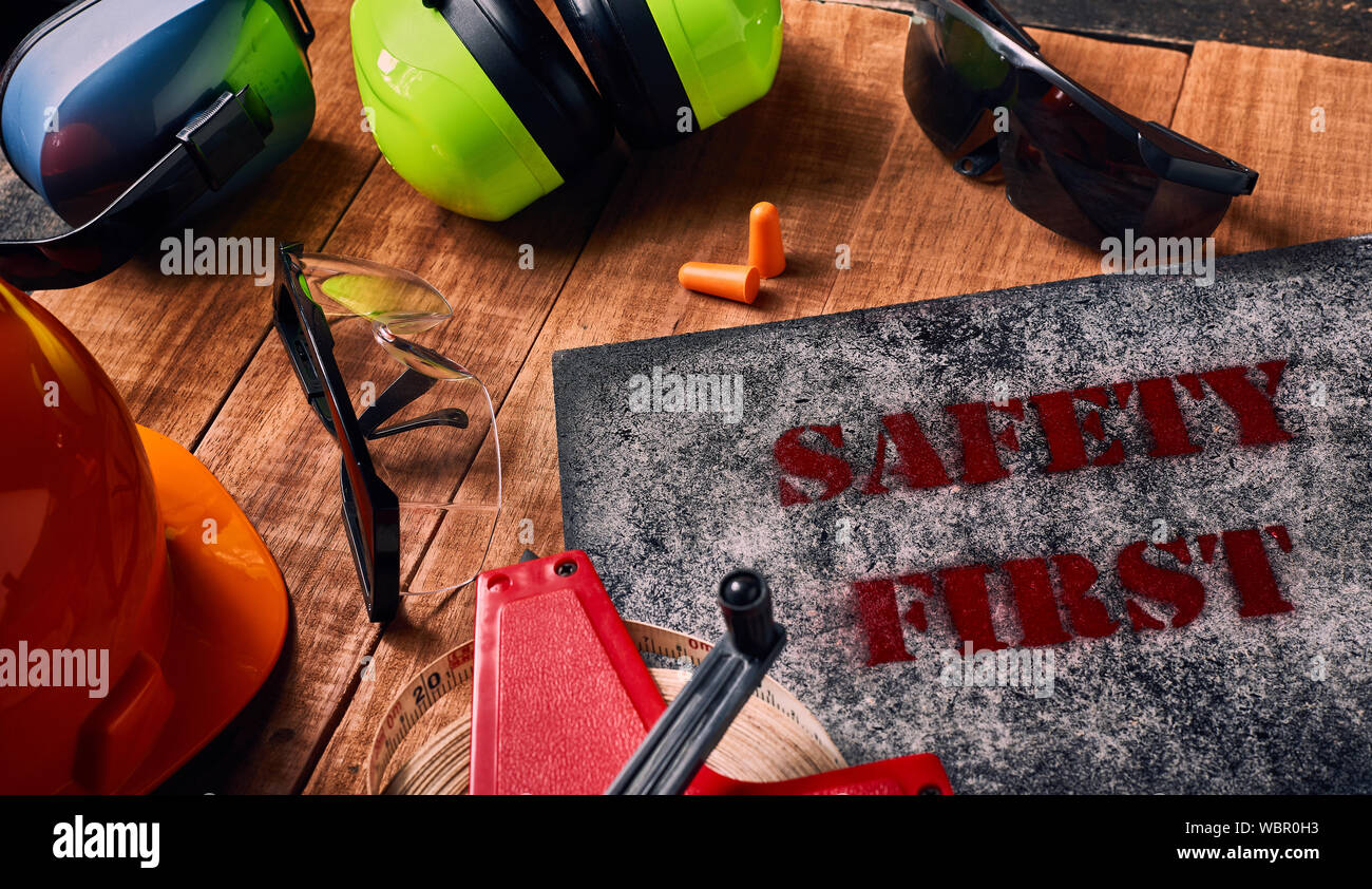 Safety first sign with personal protective equipment on wooden ...