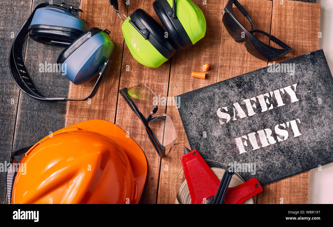 Safety first sign with personal protective equipment on wooden ...