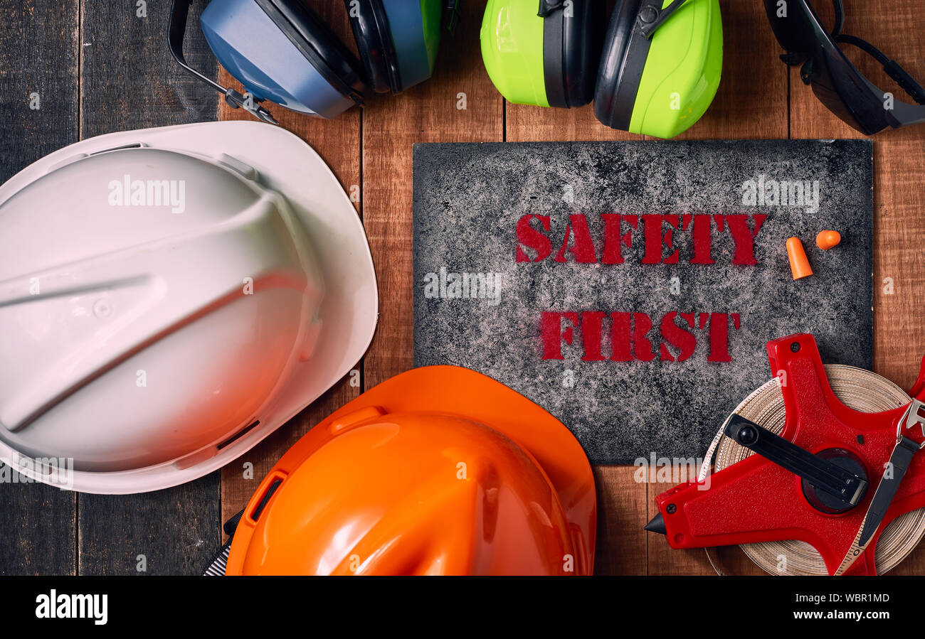 Safety first sign with personal protective equipment on wooden ...