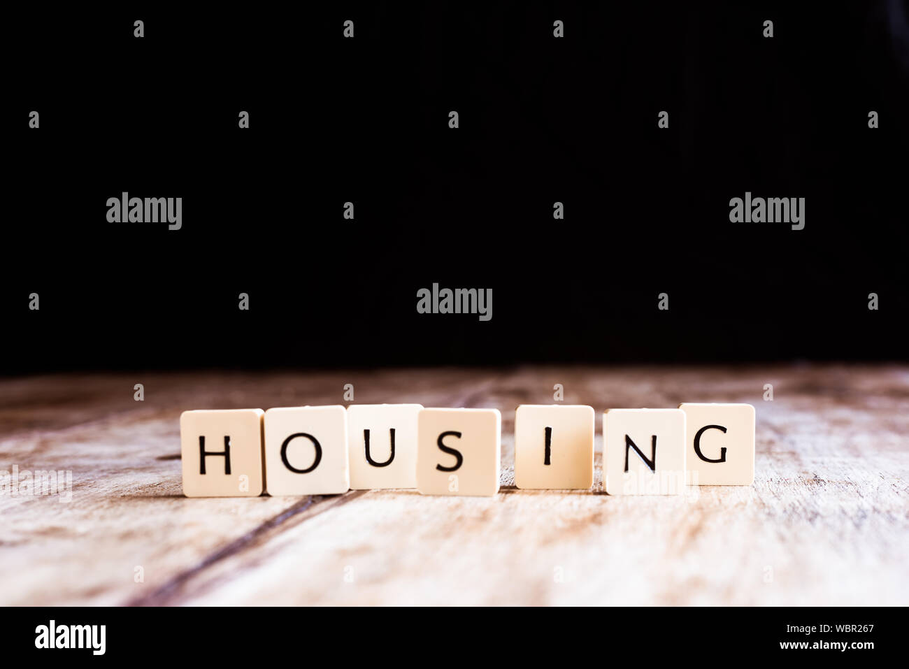 Housing word made of tiles on dark wooden background Stock Photo - Alamy