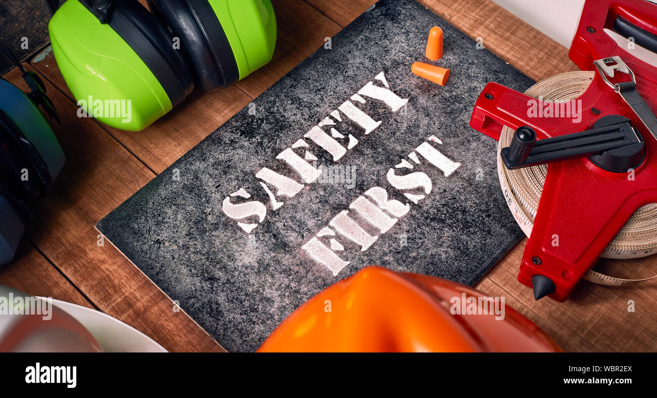 Safety first sign with personal protective equipment on wooden ...