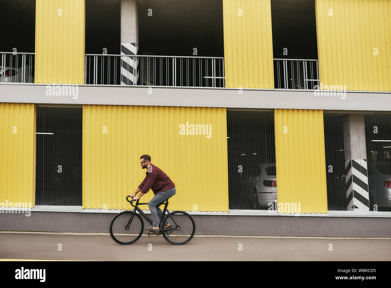 Cycling. Side view of handsome man with stubble in casual clothes ...