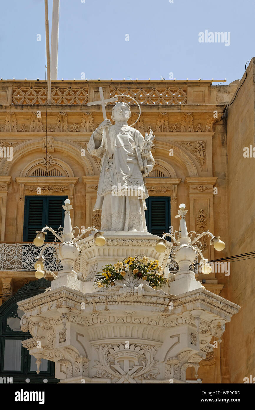 St. Lawrence statue; 16 century; stone, ornate pedestal; flowers ...