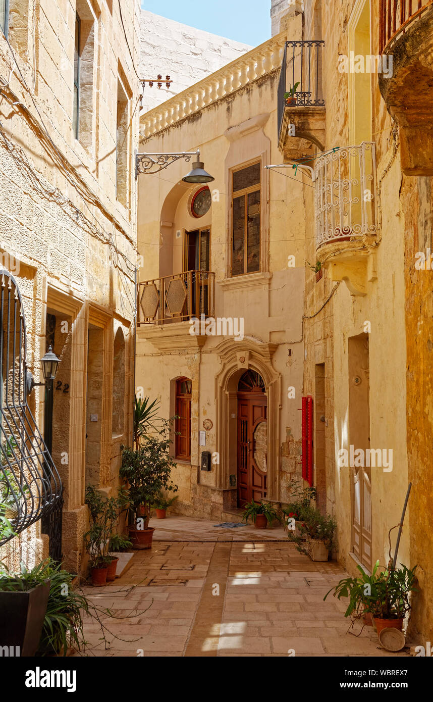 narrow pedestrian street, city scene; old limestone buildings; small ...