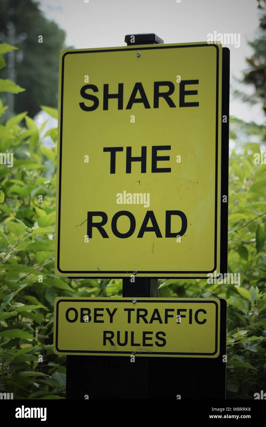 Yellow Information Sign By Plants Stock Photo - Alamy