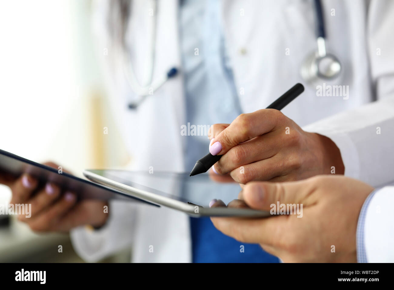 Female GP making electronic notes in tablet pc Stock Photo - Alamy