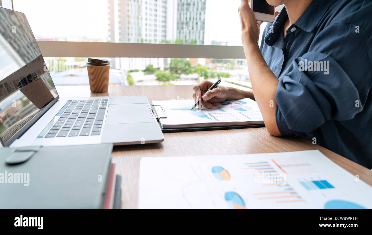 Business man working with graph data in laptop and documents on his ...