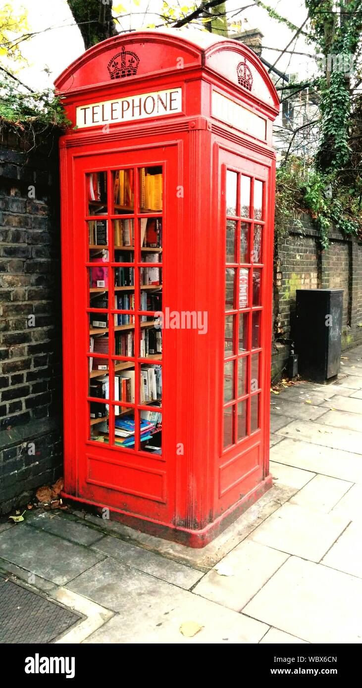 Red Telephone Booth Against Wall Stock Photo - Alamy