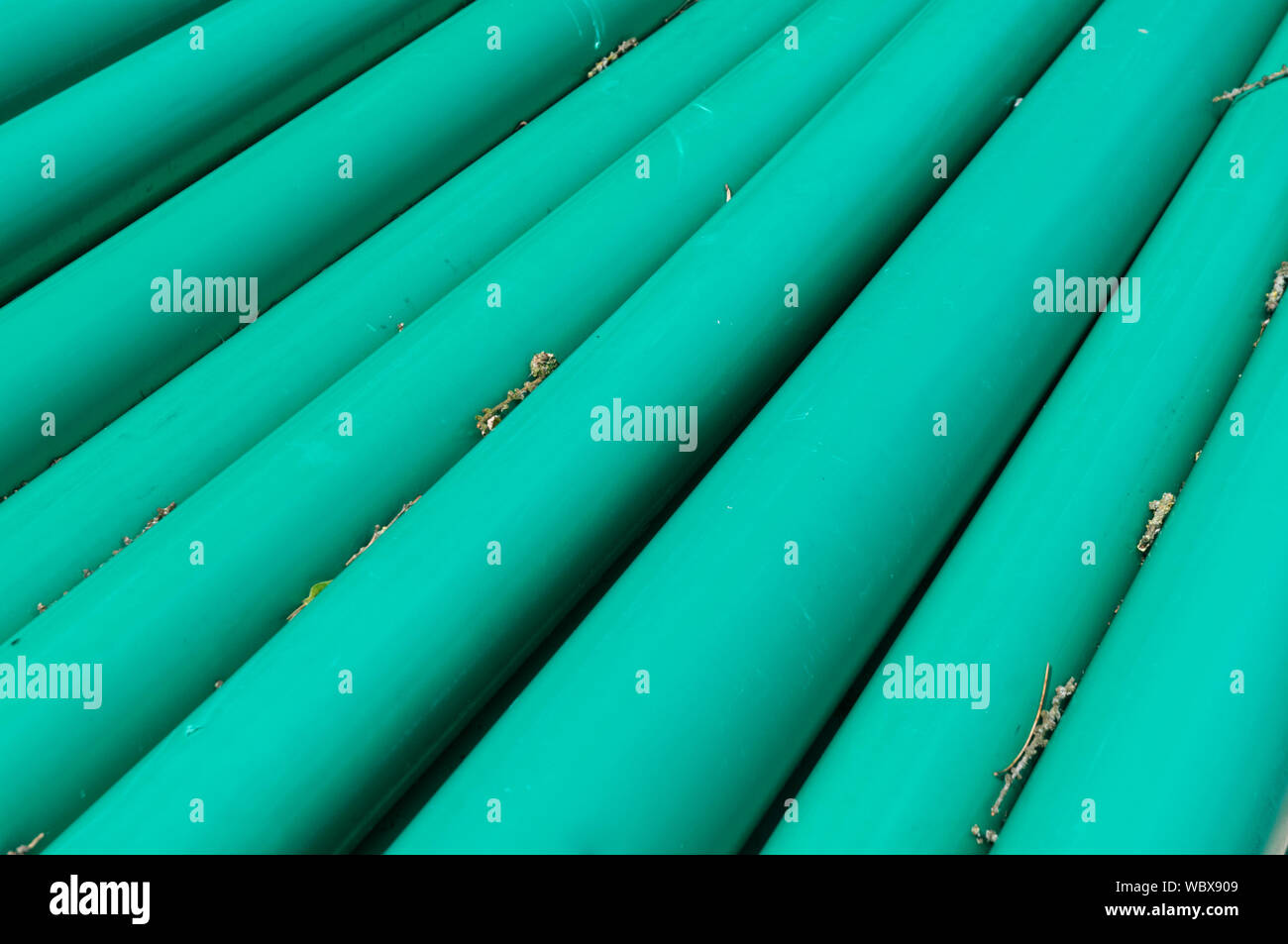 close-up of green pipes stacked at construction site for sanitary ...