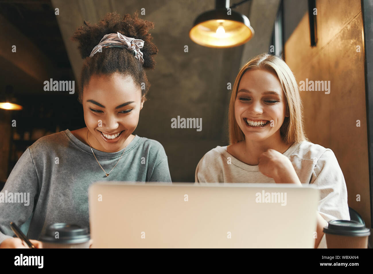 Portrait of two multiracial young female friends surfing the internet ...