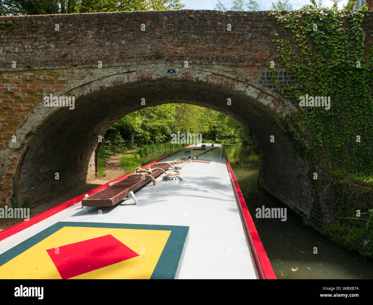Canal boat going under a bridge on The Grand Union Canal ...