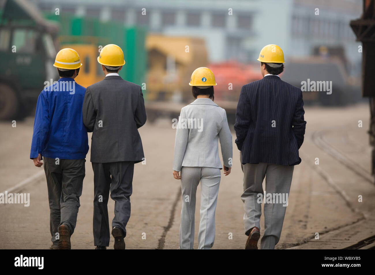 Group of business people wearing hard hats walking along a wharf Stock ...