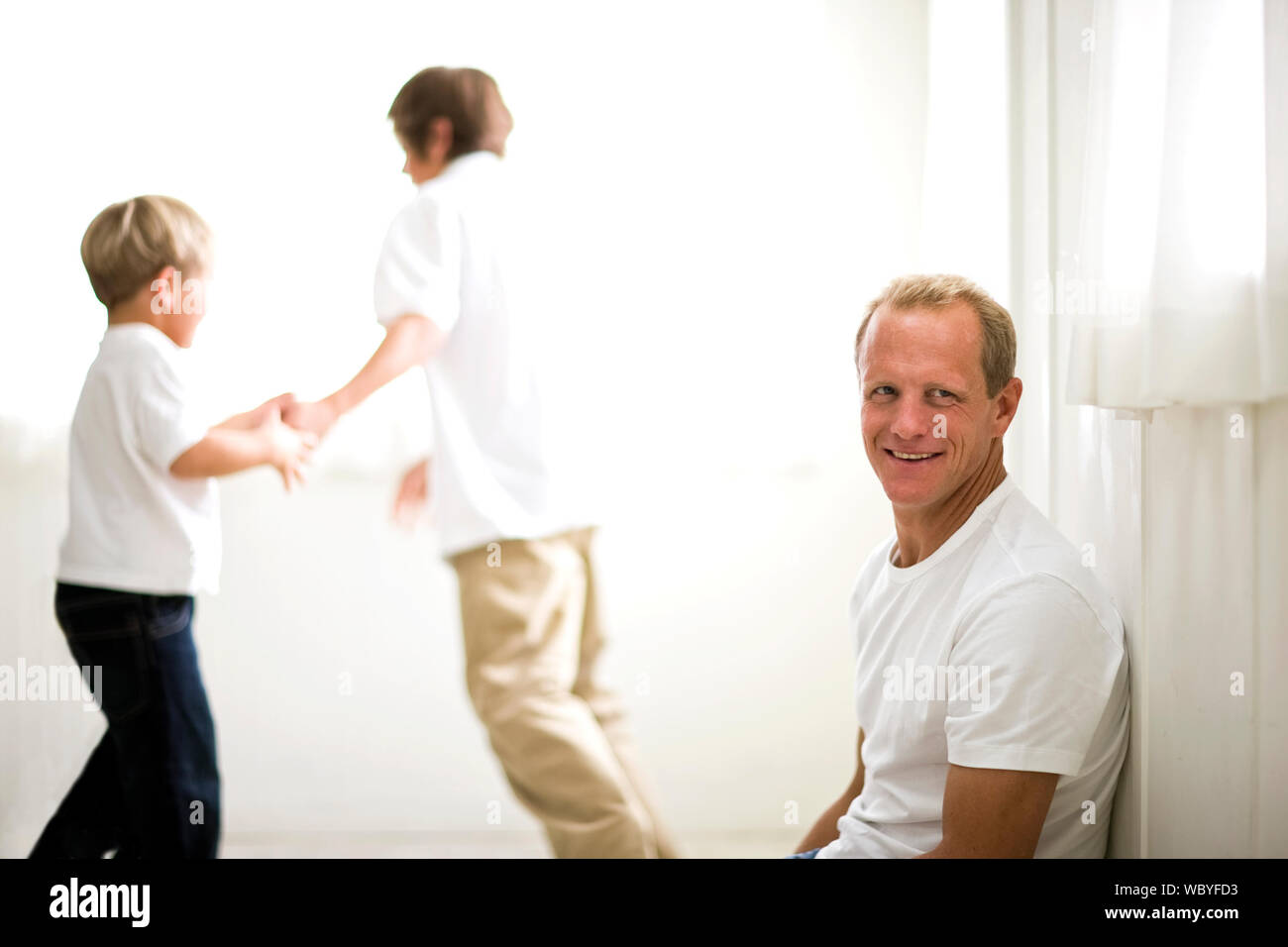 Father playing with his two young sons inside his home Stock Photo - Alamy