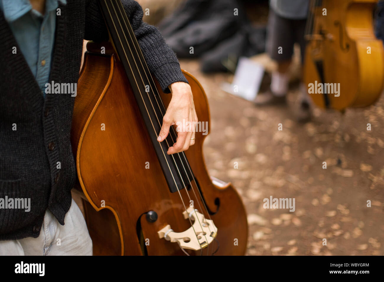 Chello being held by a musician Stock Photo - Alamy